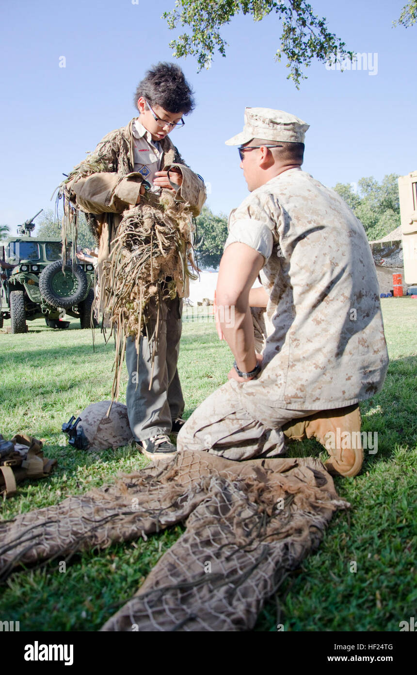 Boy Scout Etienne Salle tries on a ghillie suit with assistance from ...