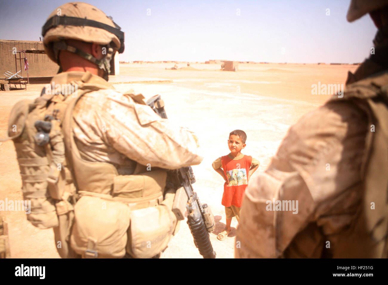 Though occupied with the attention of a young Iraqi boy, Lance Cpl ...