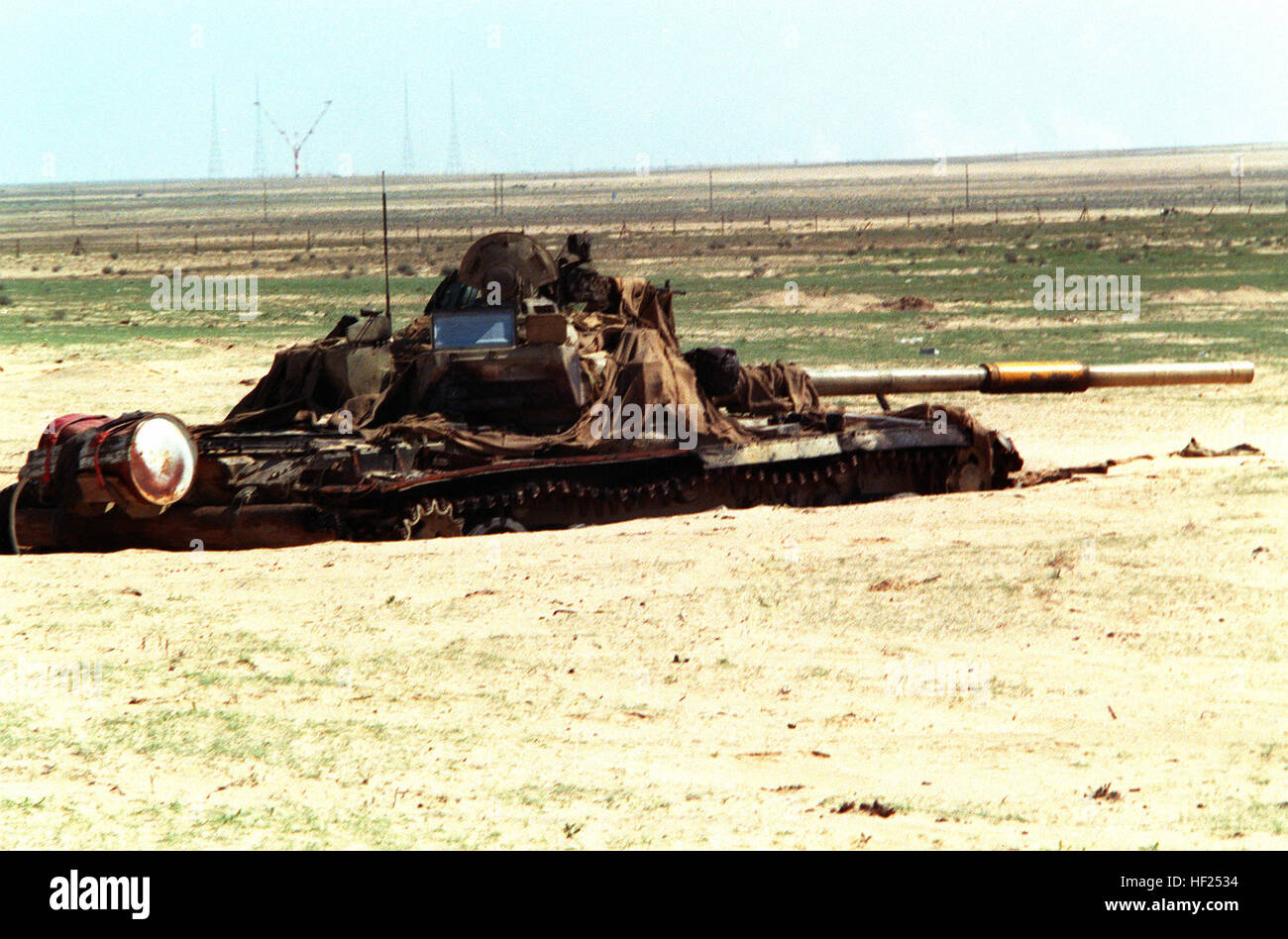 A Iraqi tank destroyed by coalition forces rests in its dug-in position ...