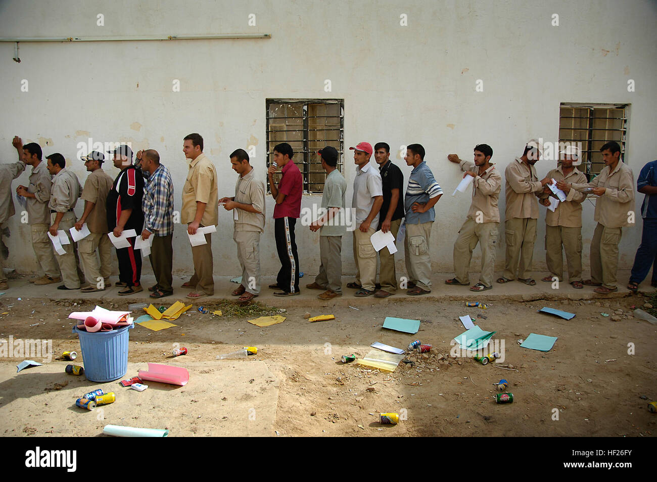 Local Iraqis line up outside of an Iraqi police station in Tarmiyah ...
