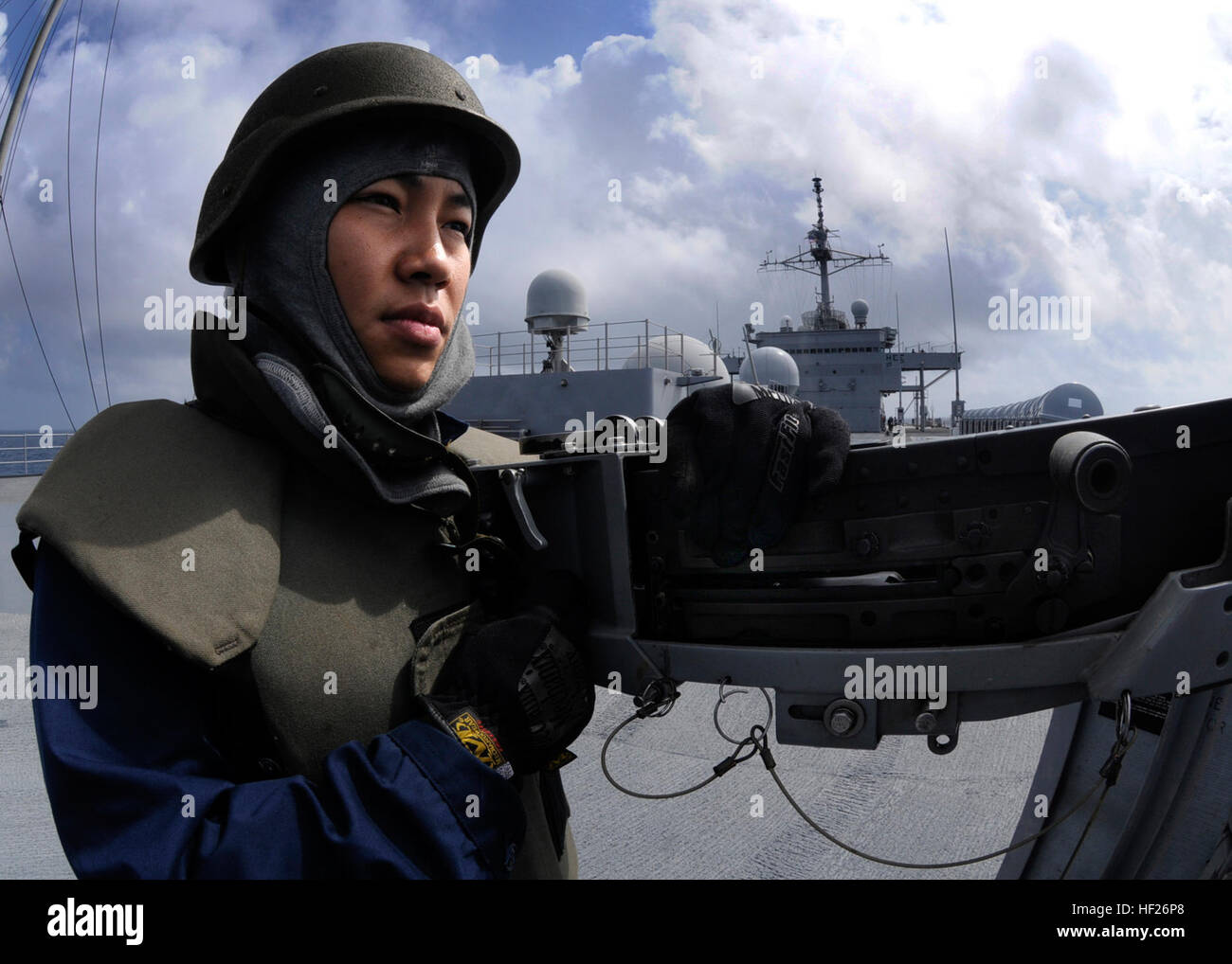 Storekeeper Petty Officer 2nd Class Chris Noerjadi mans a .50 caliber ...