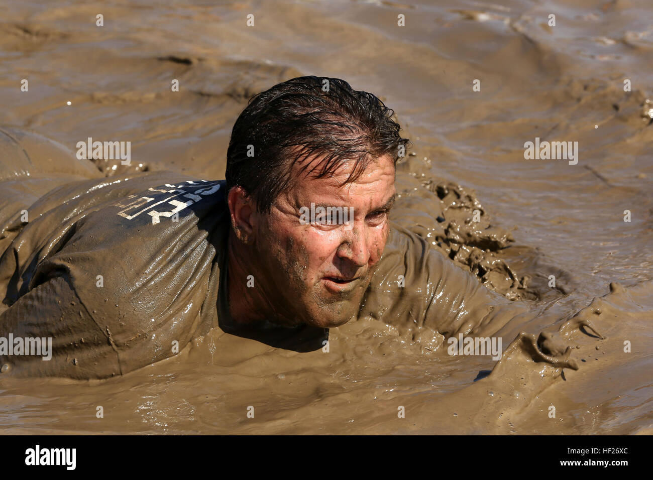 A participant swims through a mud pit during the Mud Run at Lake O ...