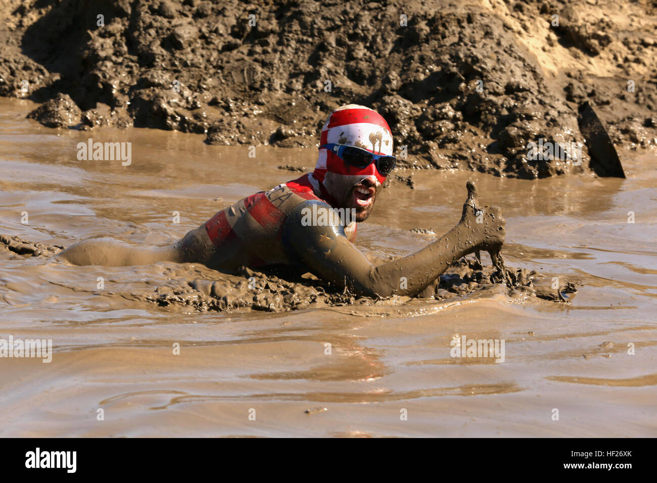 A participant swims through a mud pit during the Mud Run at Lake O ...