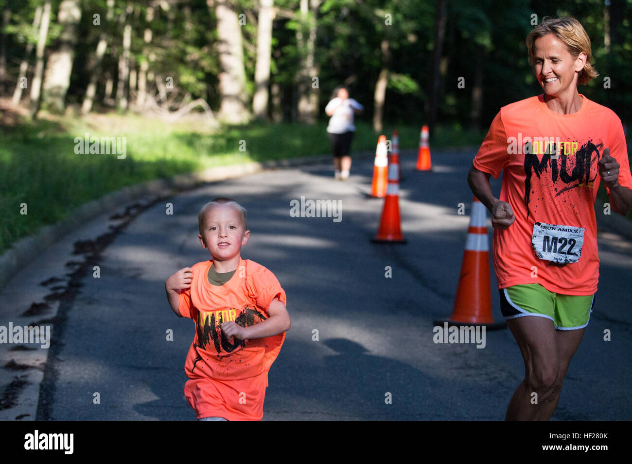 A boy and a woman run to the next obstacle during the annual Marine ...
