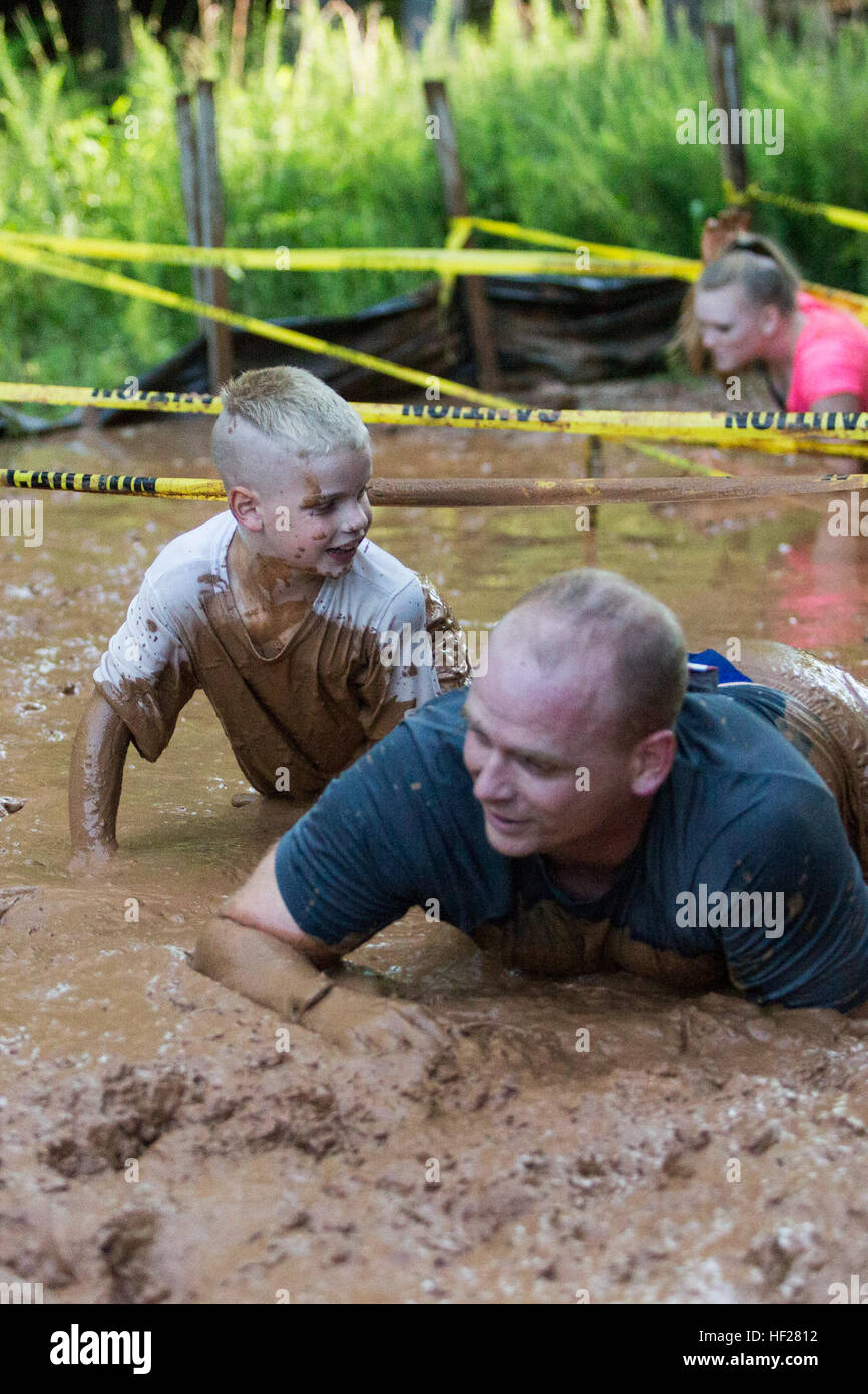 A young boy concurs a mud pit obstacle during the annual Marine Corps ...