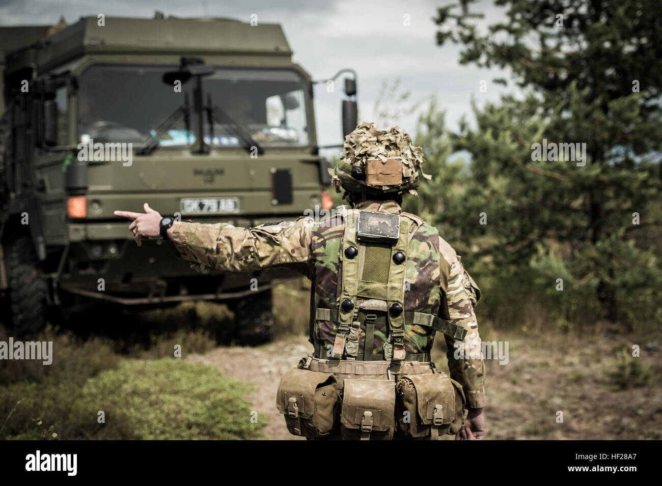 A British Army Soldier directs a vehicle at a defensive point during ...