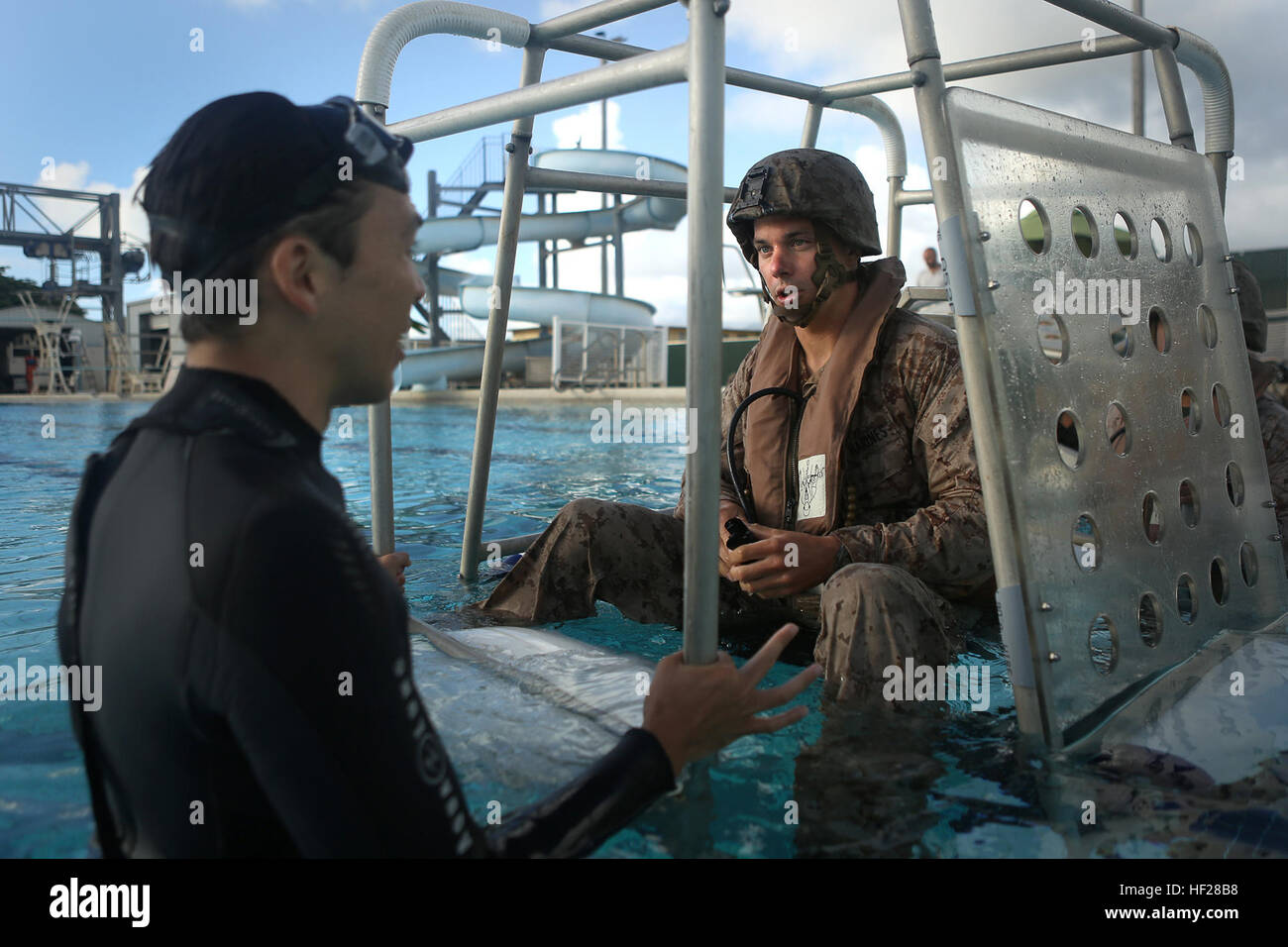 A Marine prepares to roll over in a shallow water egress training chair ...