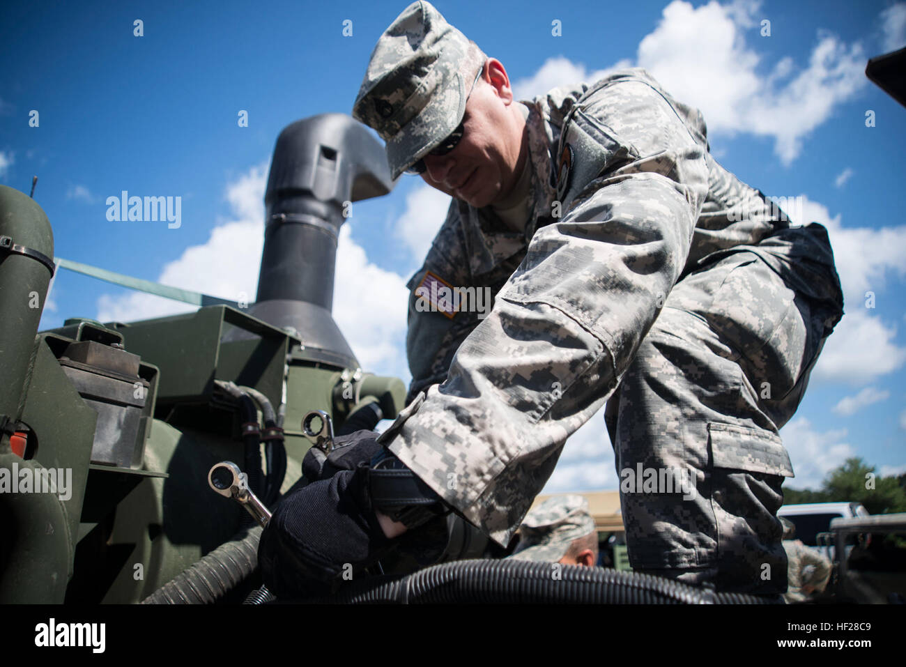 A soldier working at Peason Ridge removes a fuel filter from a M-1078 ...