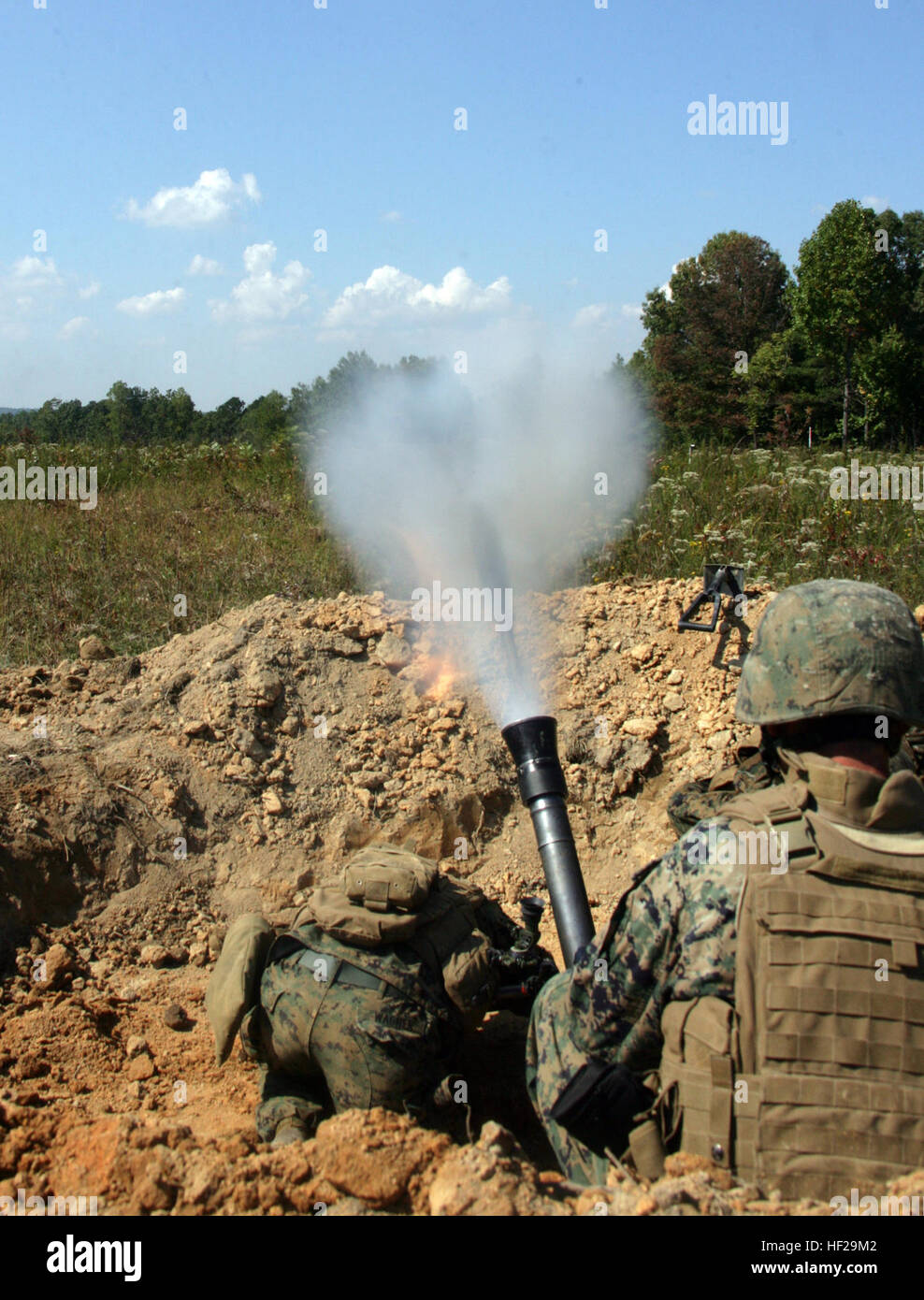 A high-explosive projectile streaks out of an 81mm mortar system as ...