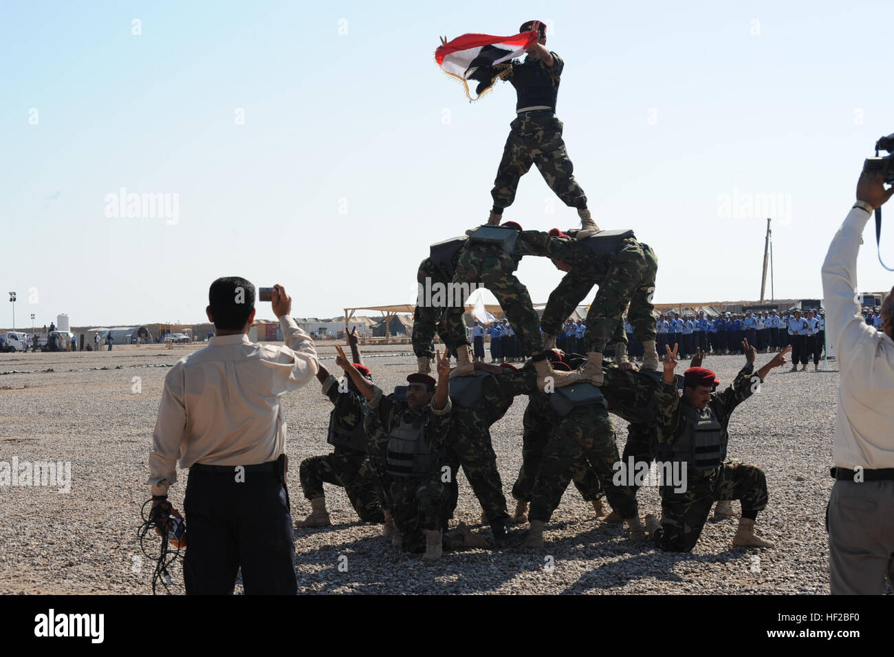 Iraqi police officers perform a human pyramid at the IP graduation at ...