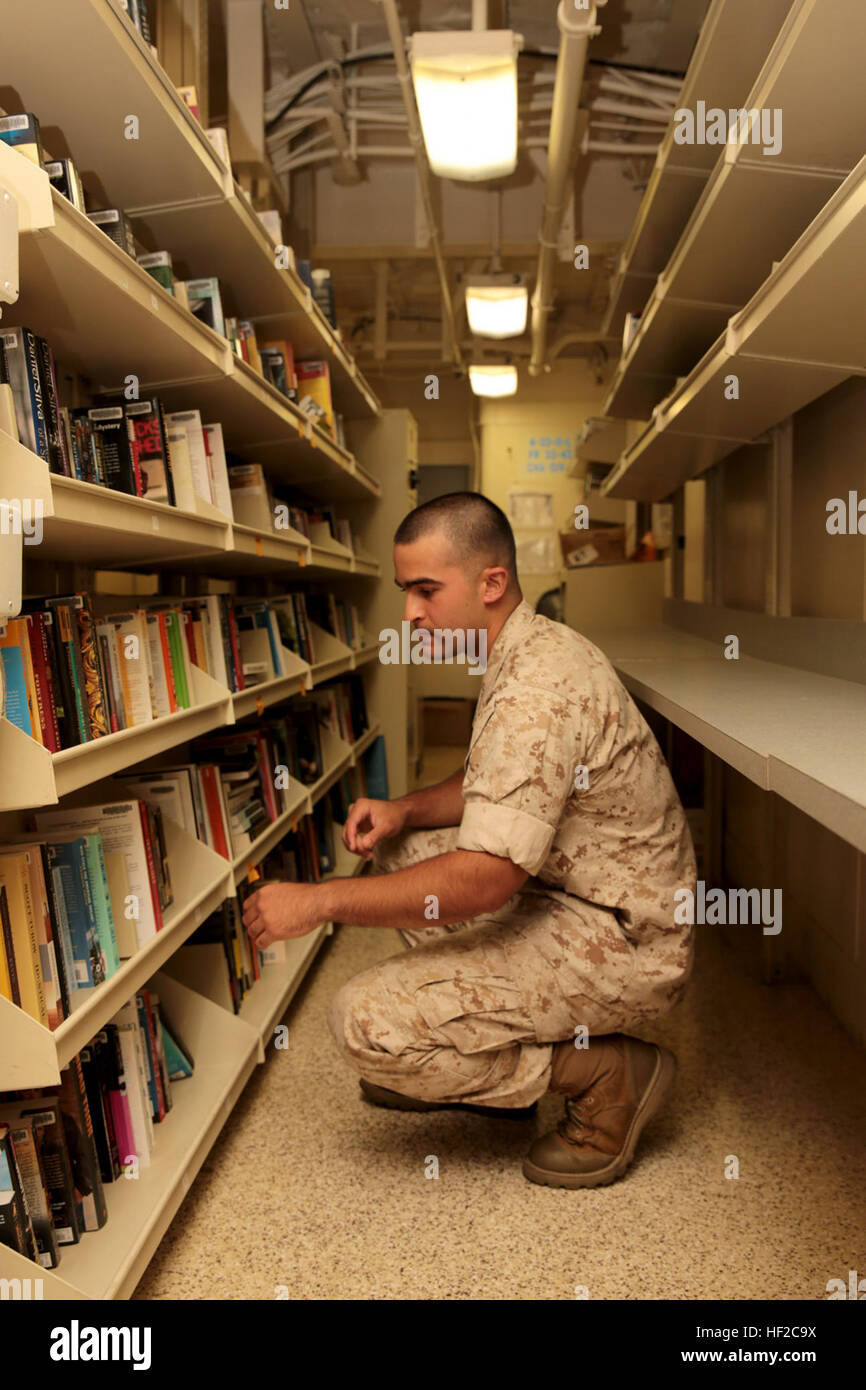A Marine with the 11th Marine Expeditionary Unit browses the book ...