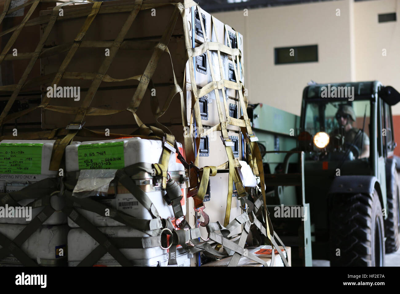 A Marine moves gear from a hangar to a staging area next to the flight ...