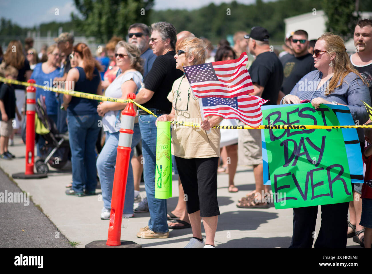 Family and friends hold signs and wait for Soldiers of the 211th ...