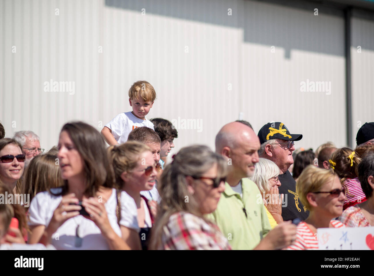 Family and friends hold signs and wait for Soldiers of the 211th ...