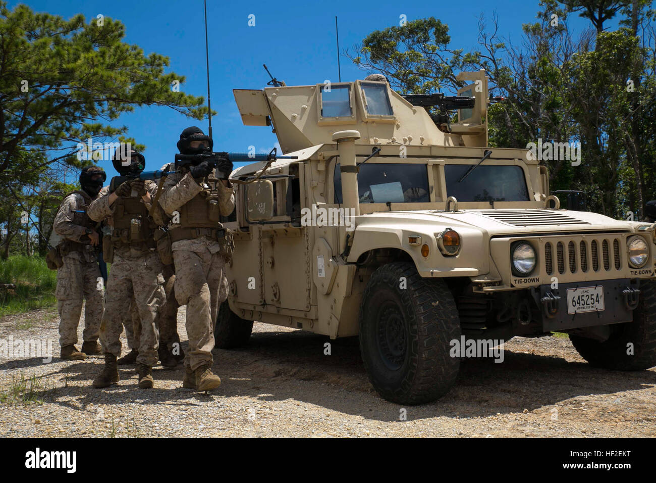 Marines advance into a town from a treeline using a Humvee for cover ...