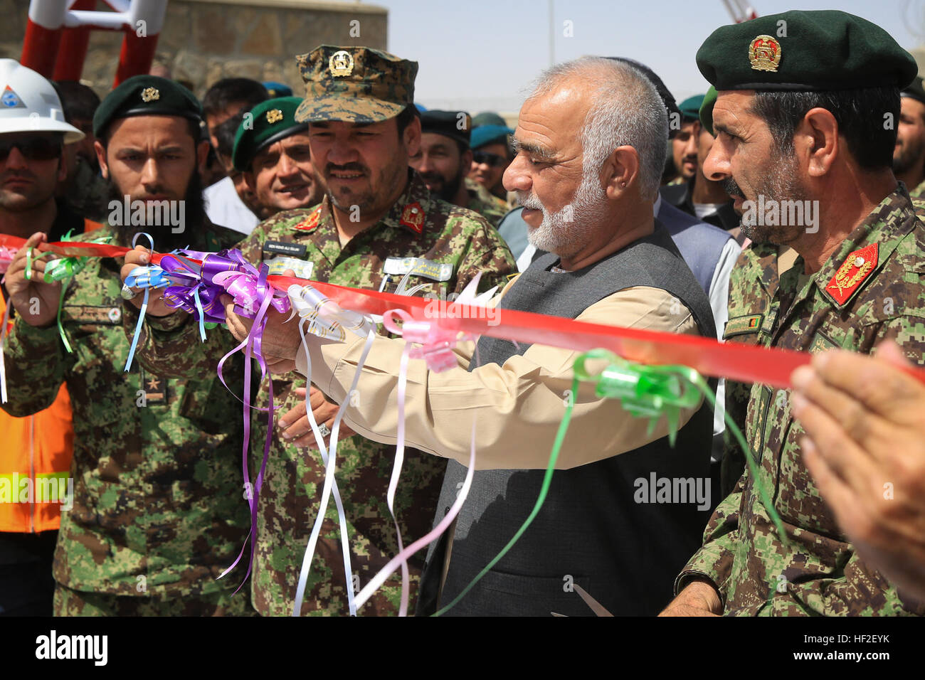 Naeem Baloch, center, the governor of Helmand province, cuts a ribbon ...