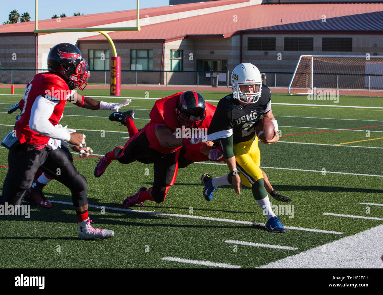 Players with the Marine Corps Air Station Miramar Falcons drag down the ...