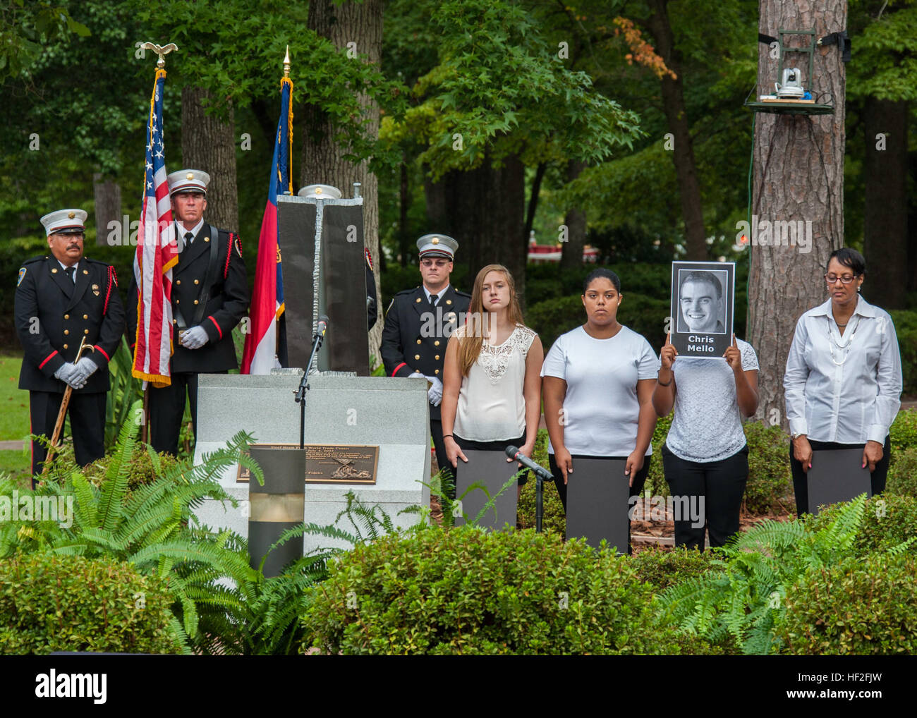 A representative displays a photo of Chris Mello, a victim of the Sept ...