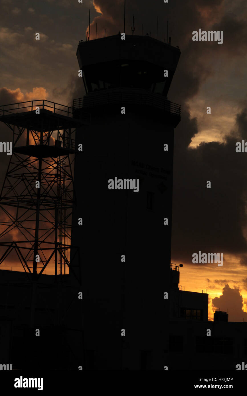 The air traffic control tower is silhouetted by the rising sun over ...