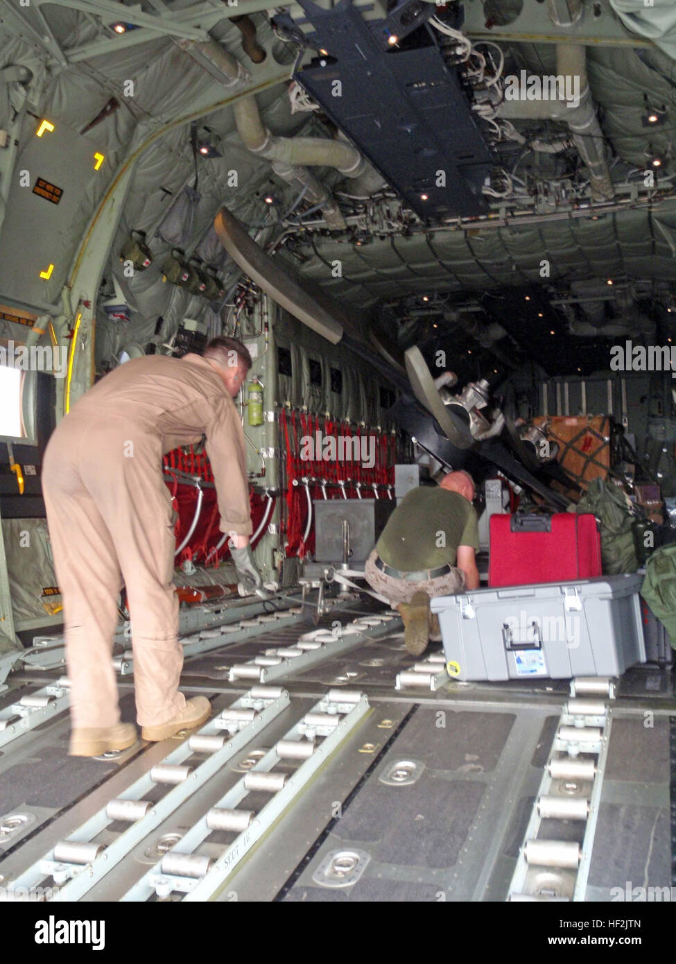 A loadmaster from VMGR-252 works to secure propeller stands inside the ...