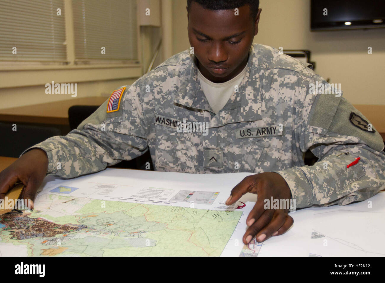 A U.S. Army soldier studies maps to verify grid placement after ...