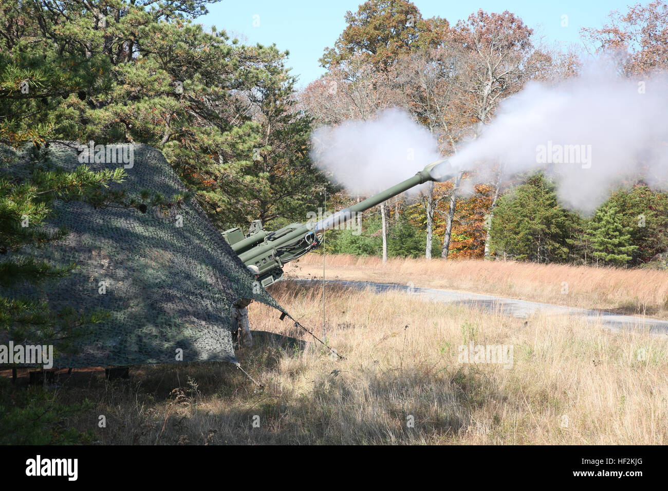 An M777A2 Lightweight Howitzer fires rounds down range as smoke from ...