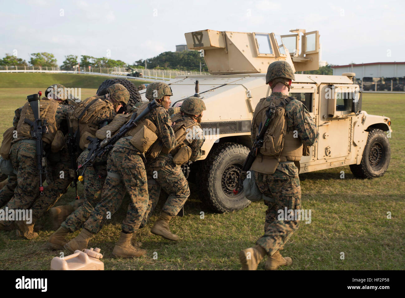 Marines push a Humvee Dec. 5 at Camp Hansen during the first ever Caltrap Challenge. The ...