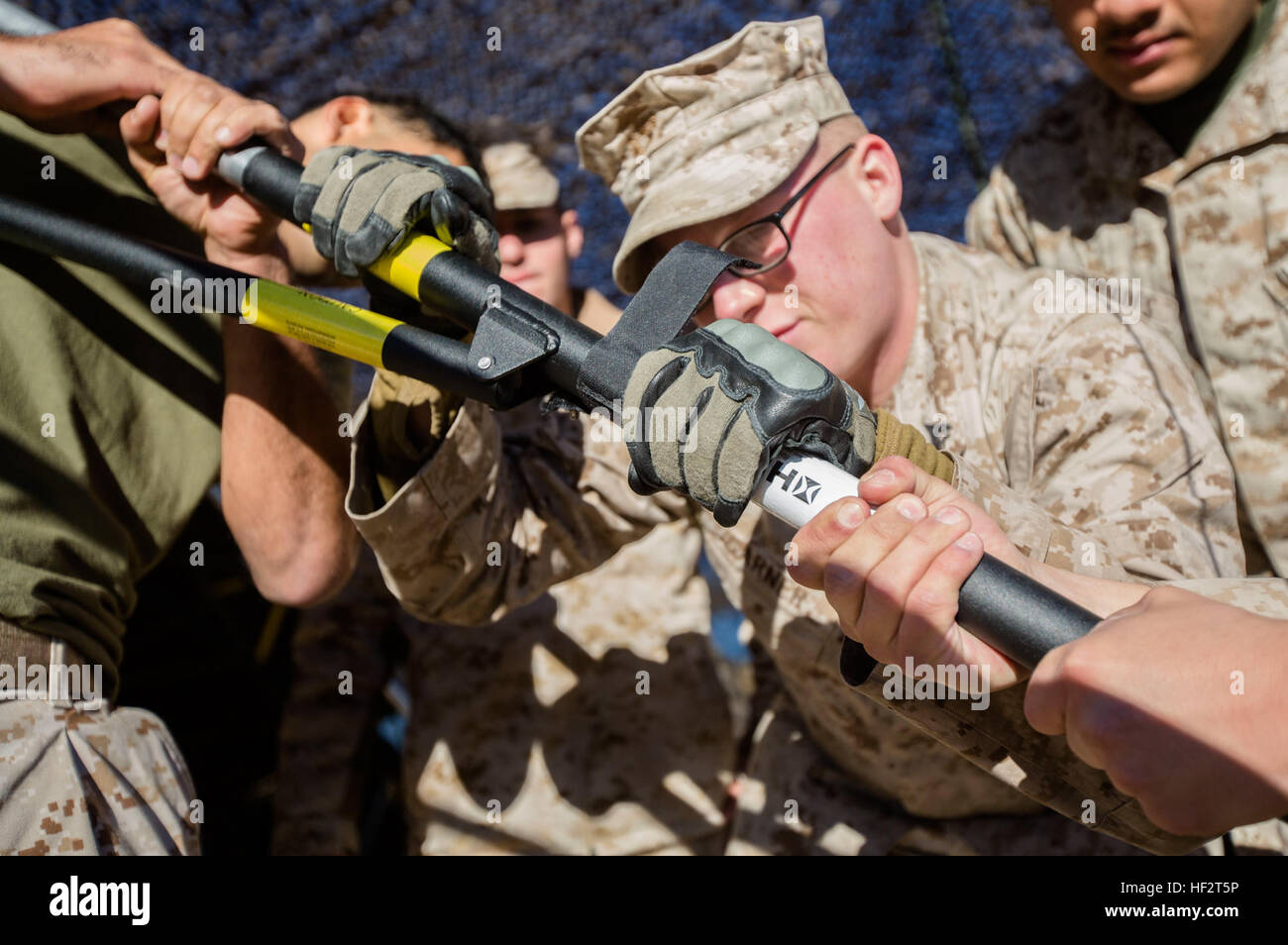 U.S. Marines assigned to 4th Marine Regiment connect tent frames during ...