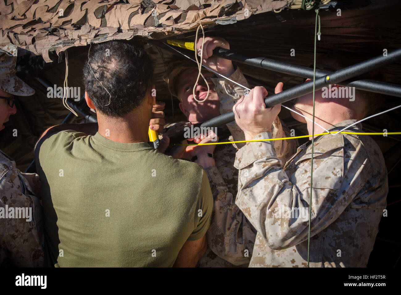 U.S. Marines assigned to 4th Marine Regiment connect tent frames during ...