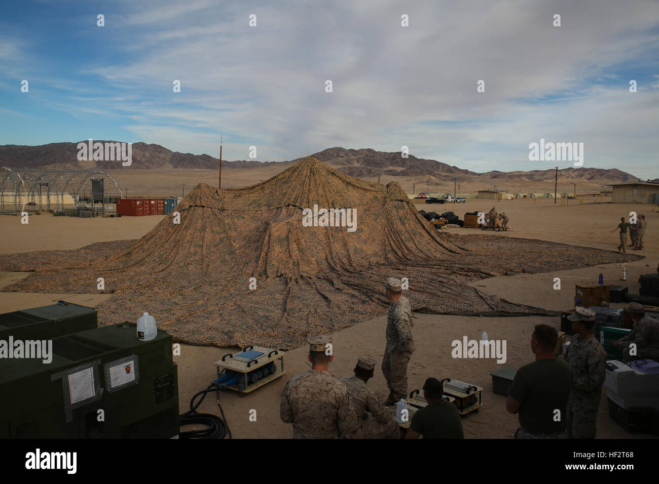 Marines set up camouflage netting as the first step in forming a combat ...