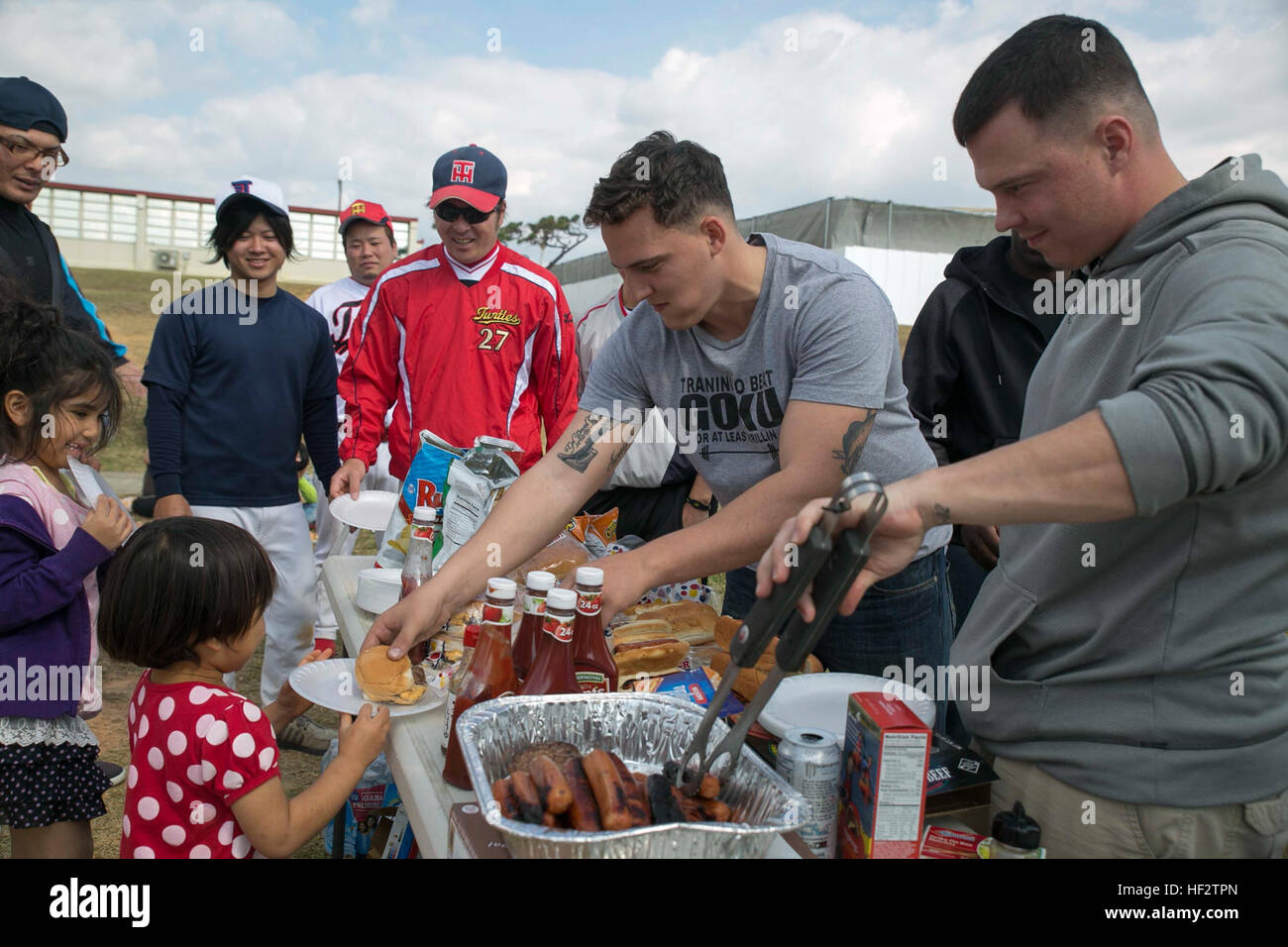 U.S. Marines serve food to Okinawan children at a cookout following a ...