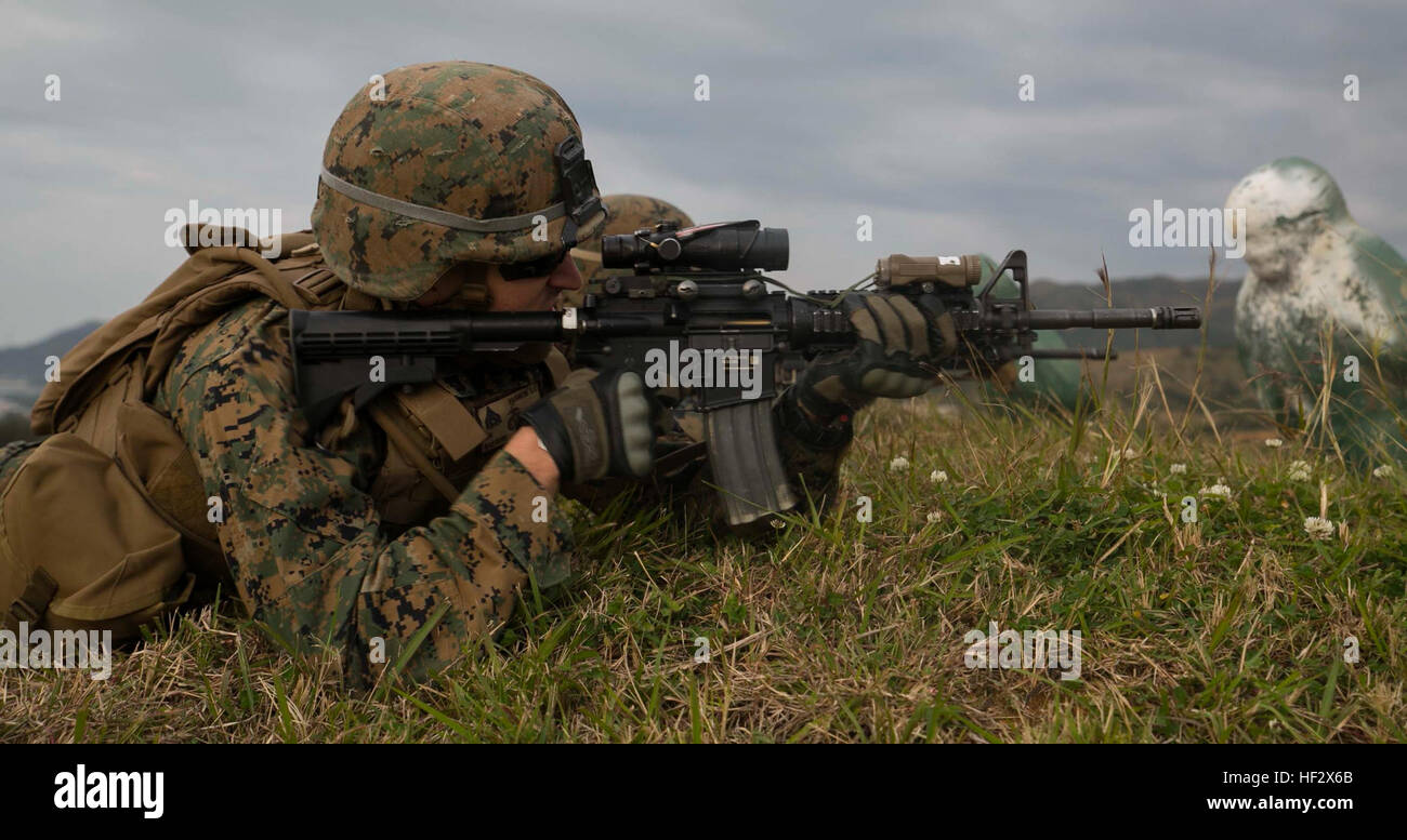 Marine fires M4A1 service rifle at a live fire range during buddy ...
