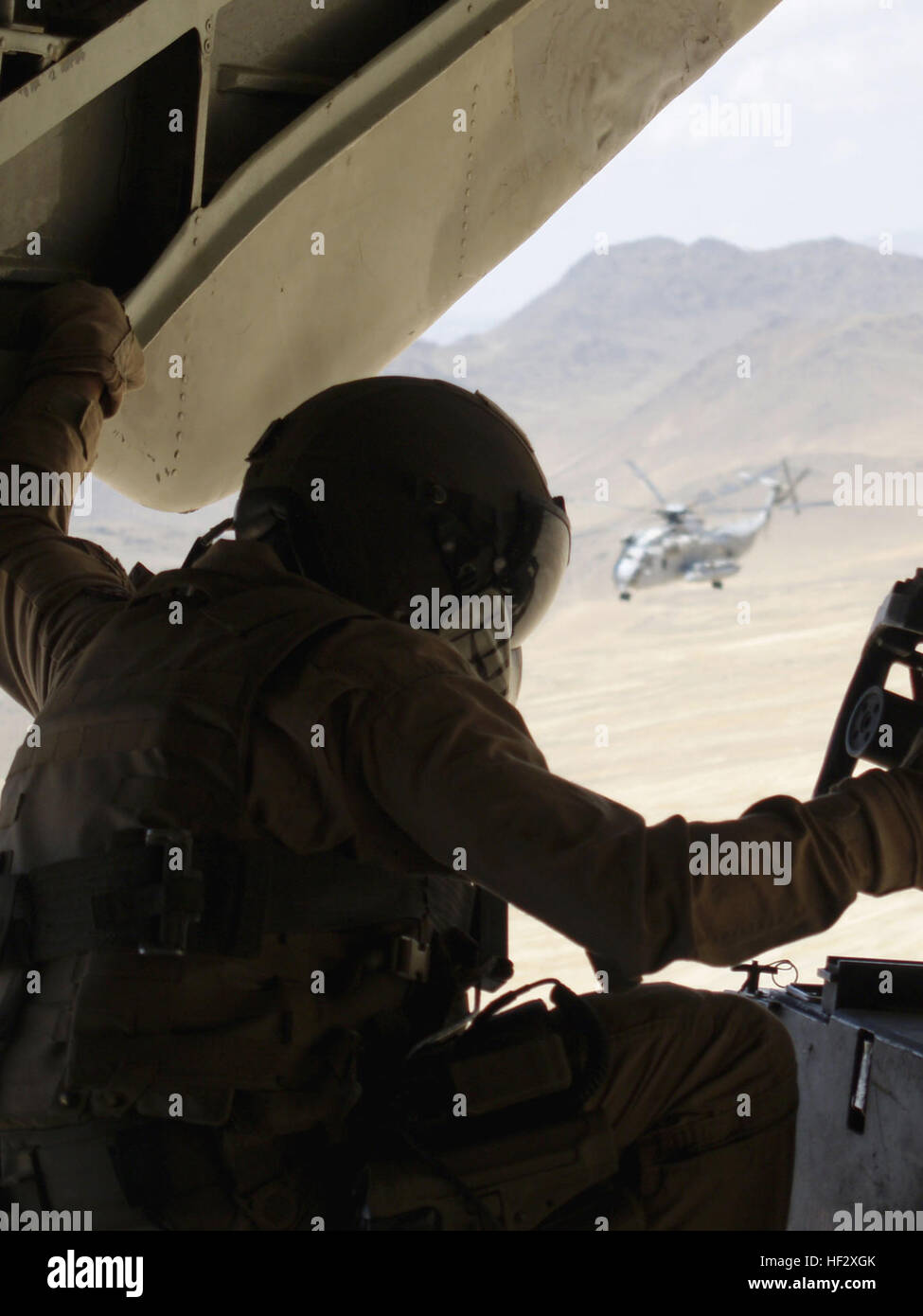 An aerial gunner observes the landscape as CH-53D Sea Stallion ...