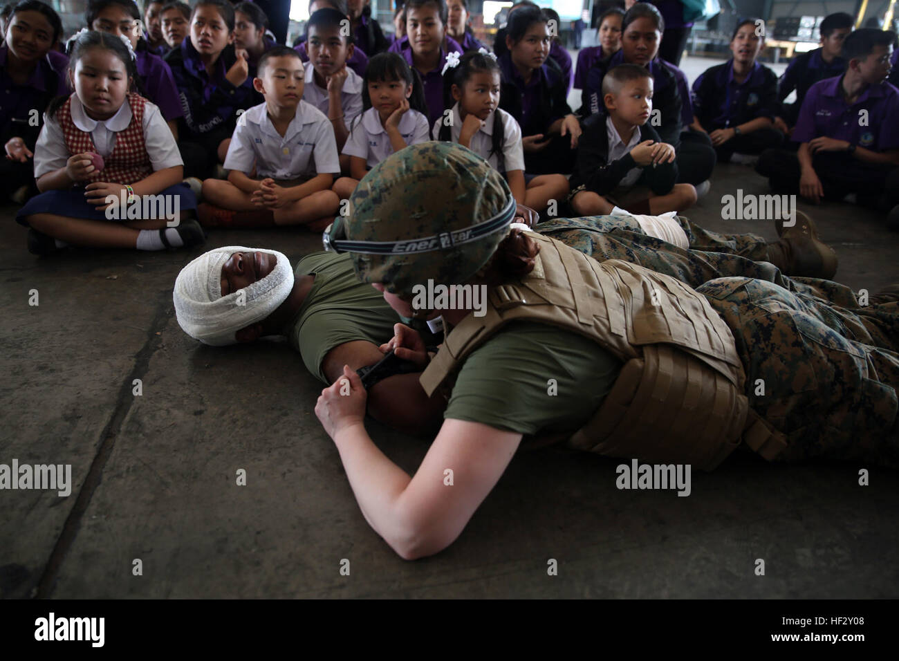 U.S. Navy Corpsmen show children from Yothinnukun School how to treat a ...