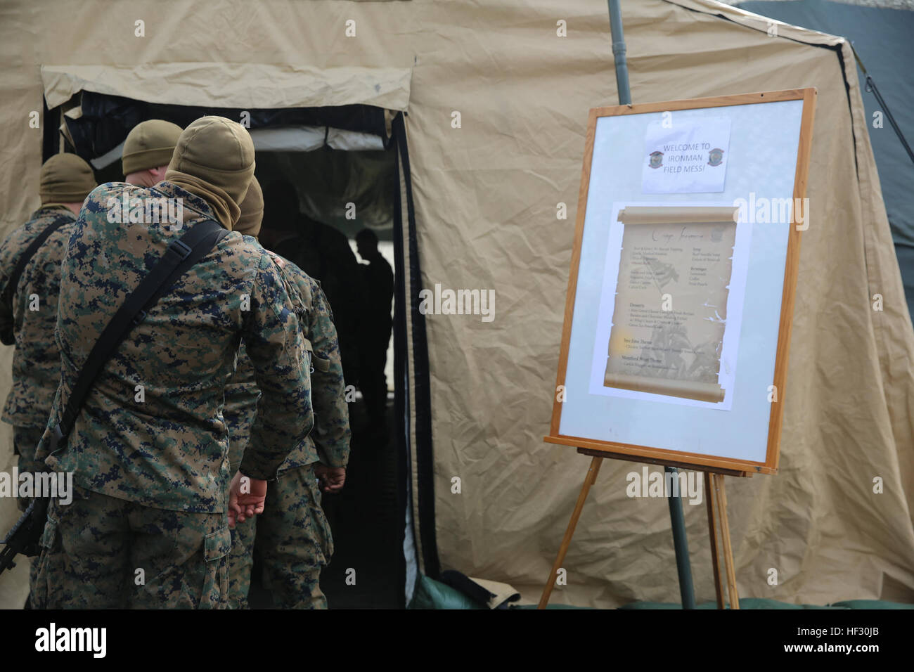Marines stand in line waiting to enter the Ironman field mess tents to ...