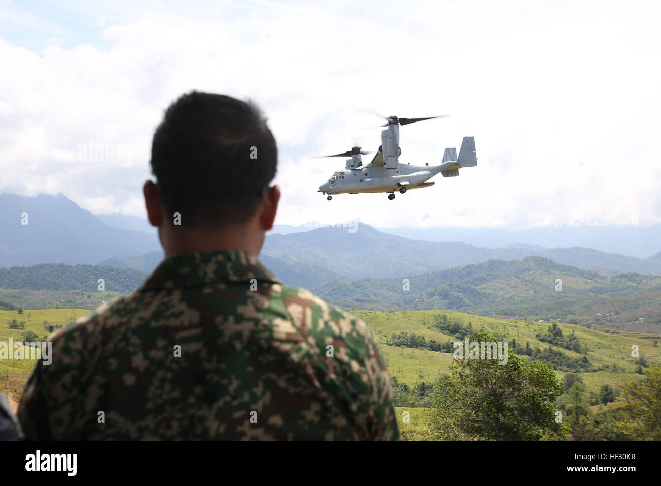 A member of the Malaysian Armed Forces watches as an MV-22B Osprey ...