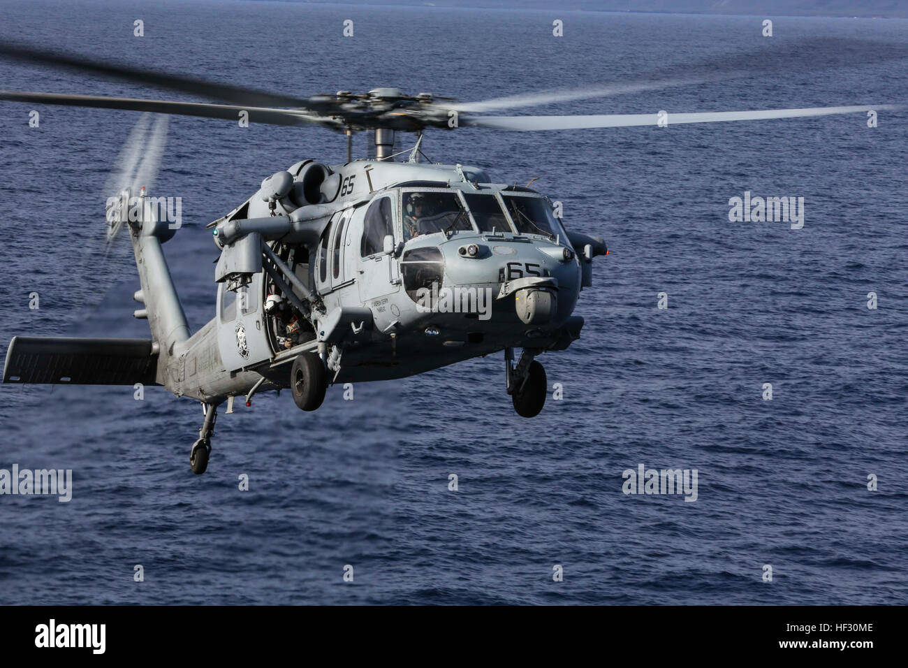 A U.S. Navy MH-60S Sea Hawk prepares to land on the USS Essex (LHD 2 ...
