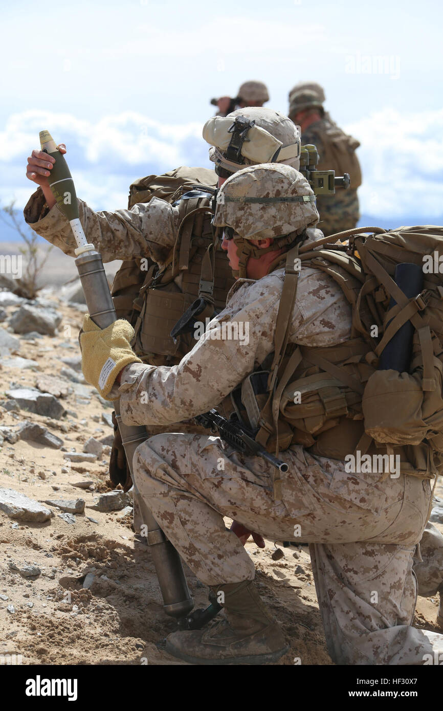 Sgt. Rebecca N. Rutherford, feeds a round into a 60 mm mortar system ...