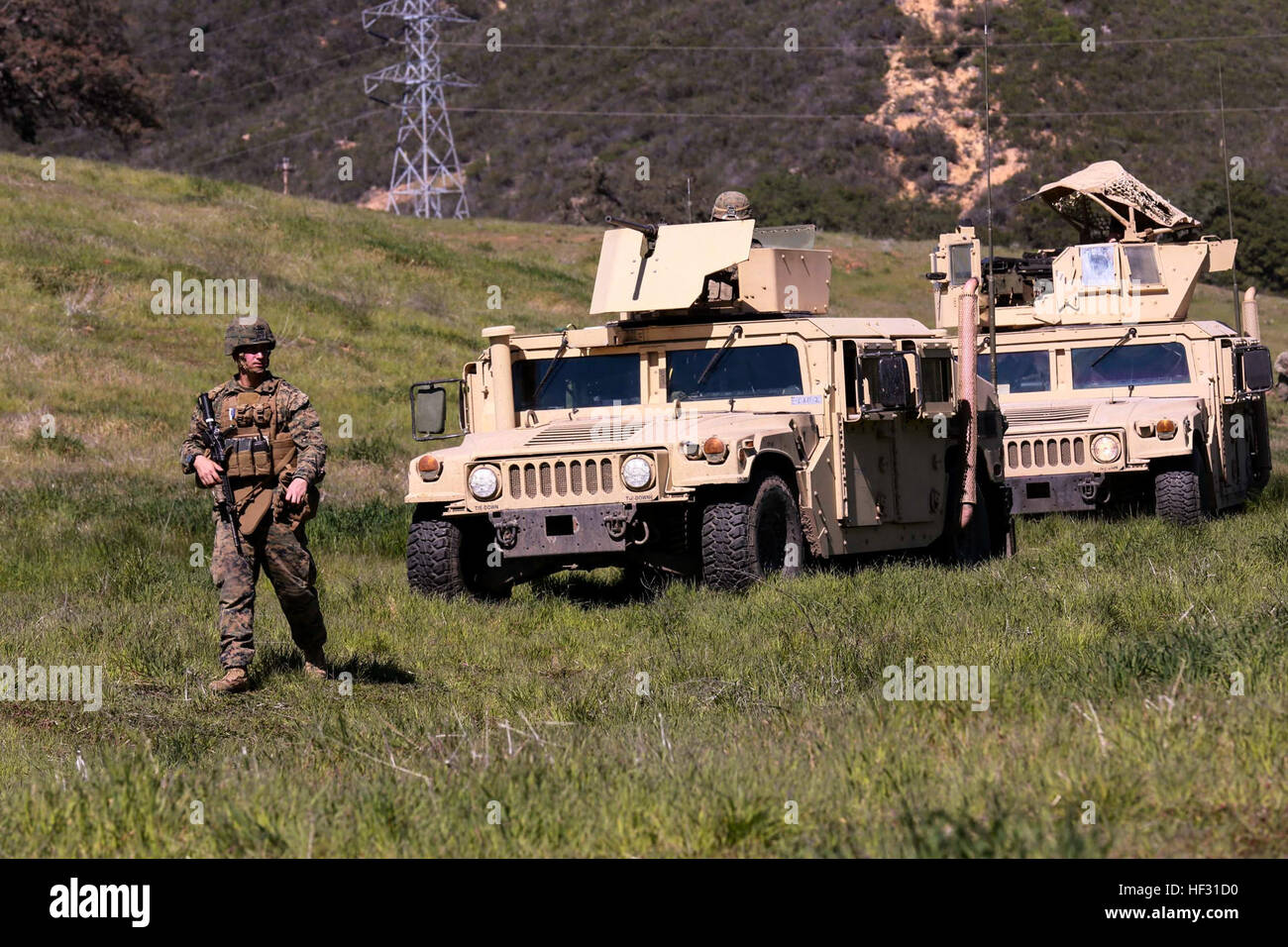 A U.S. Marine ground guides Humvees from Combined Anit-Armor Team 1 ...
