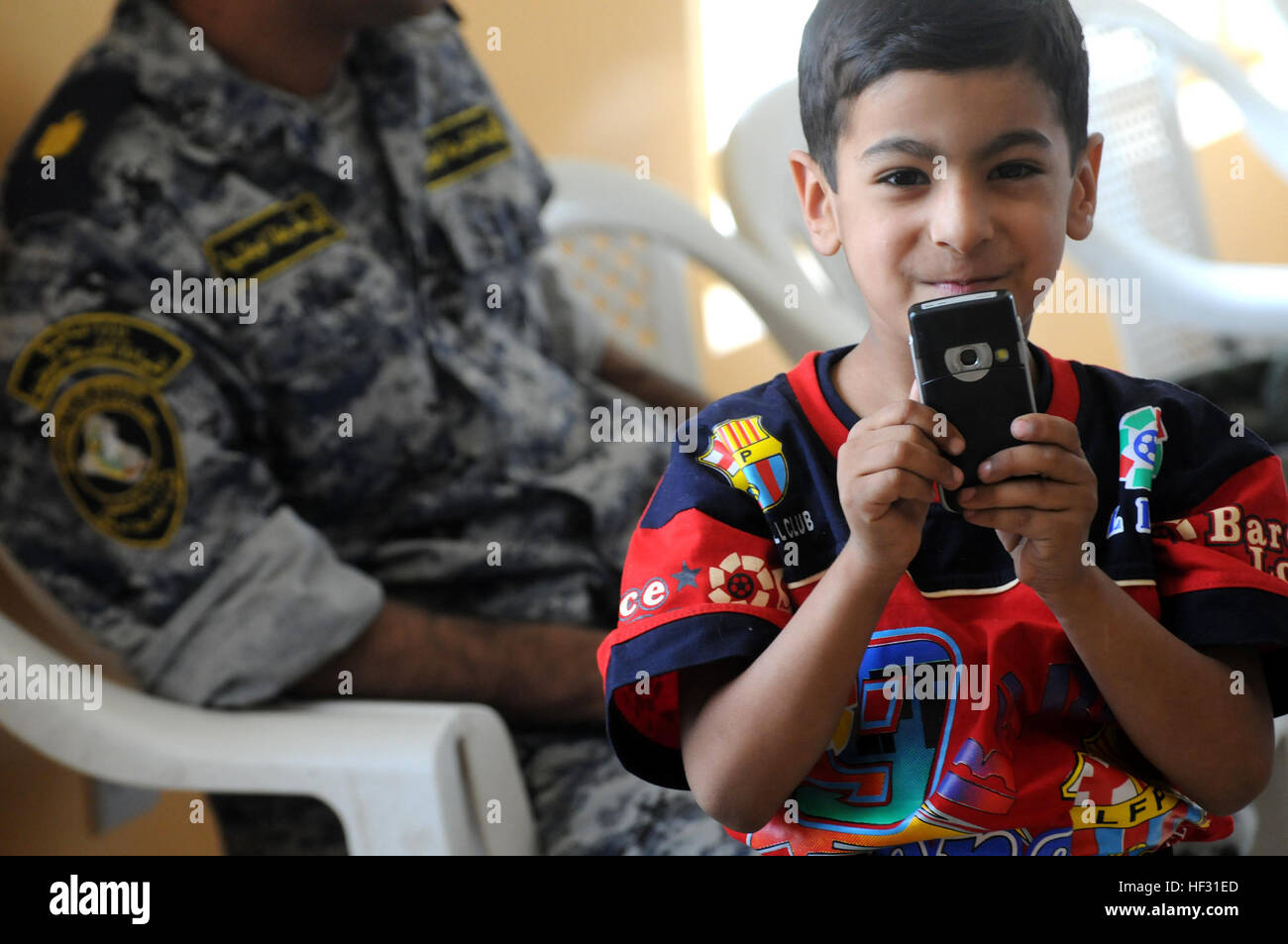 A local Iraqi boy takes photographs with a cell phone during an opening ...