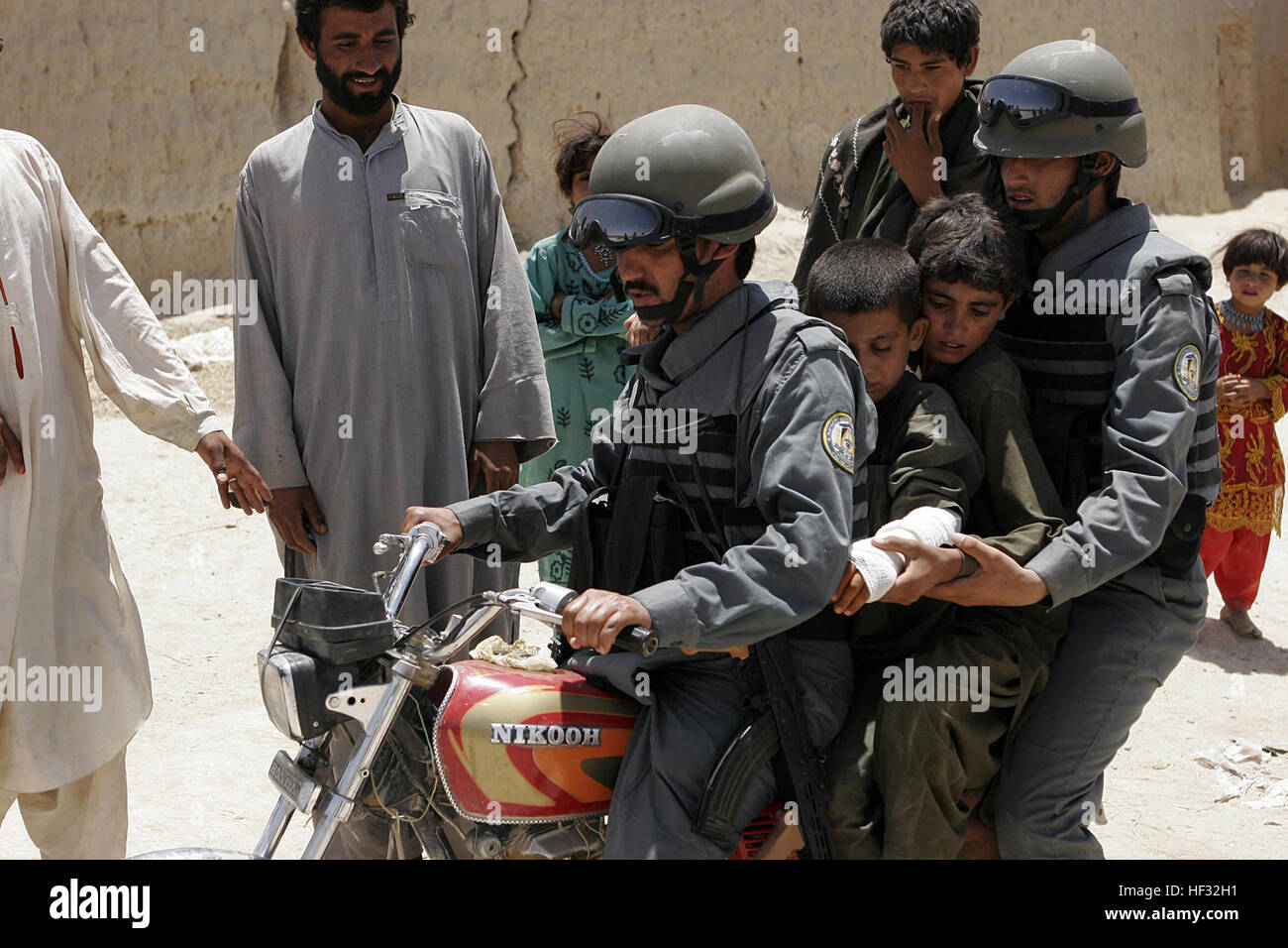 Two Afghan national police officers use a motorcycle in order to ...