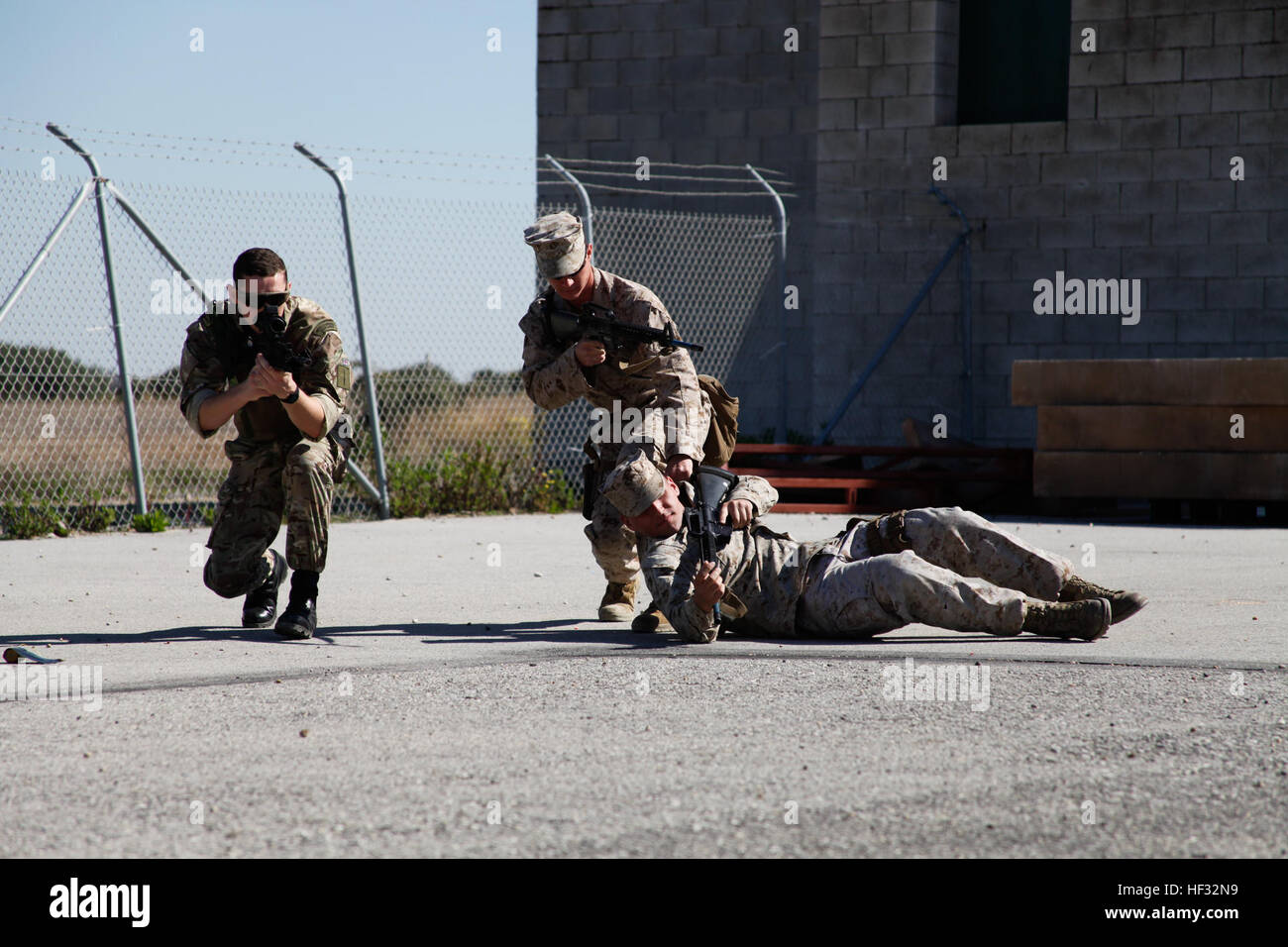 A British Royal Marine Commando provides cover to a U.S. Marine from ...