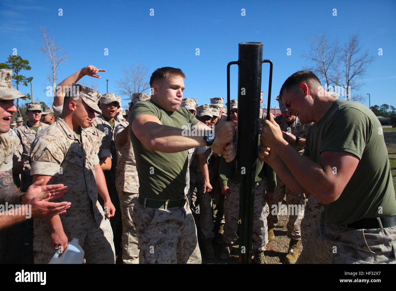 Two Marine Corps engineers drive a stake into the ground in a relay ...