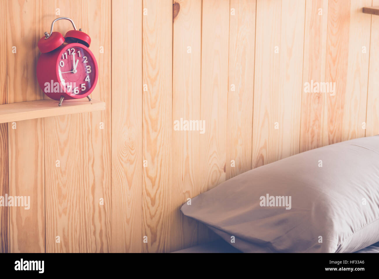 Red alarm clock on wood shelf in bedroom at home Stock Photo - Alamy
