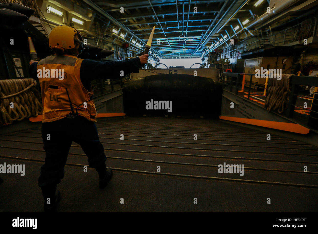 A U.S. Navy Sailor directs Landing Craft, Air Cushioned 65 with Assault ...