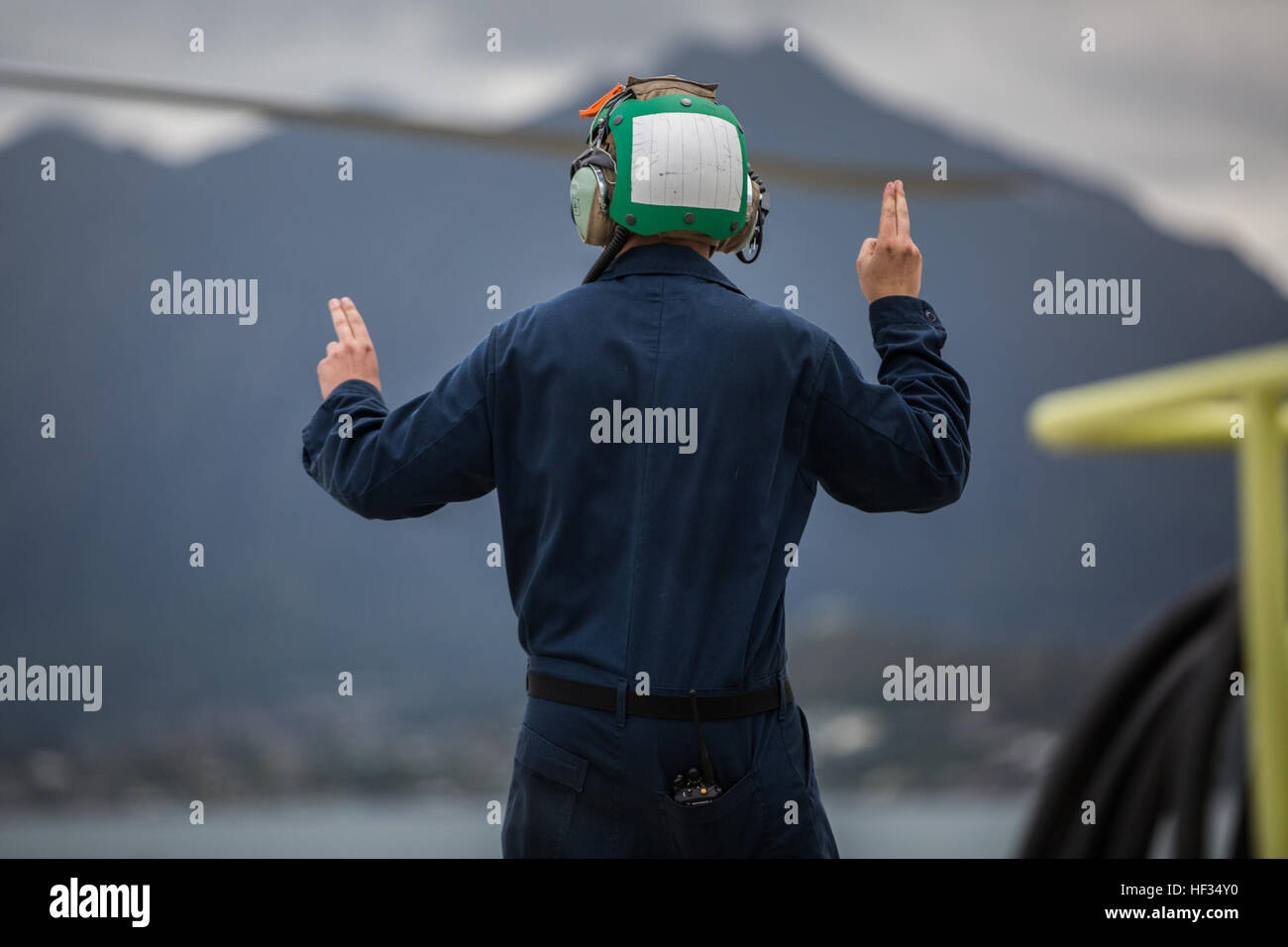 A ground guide with Helicopter Maritime Strike Squadron 37 signals to ...