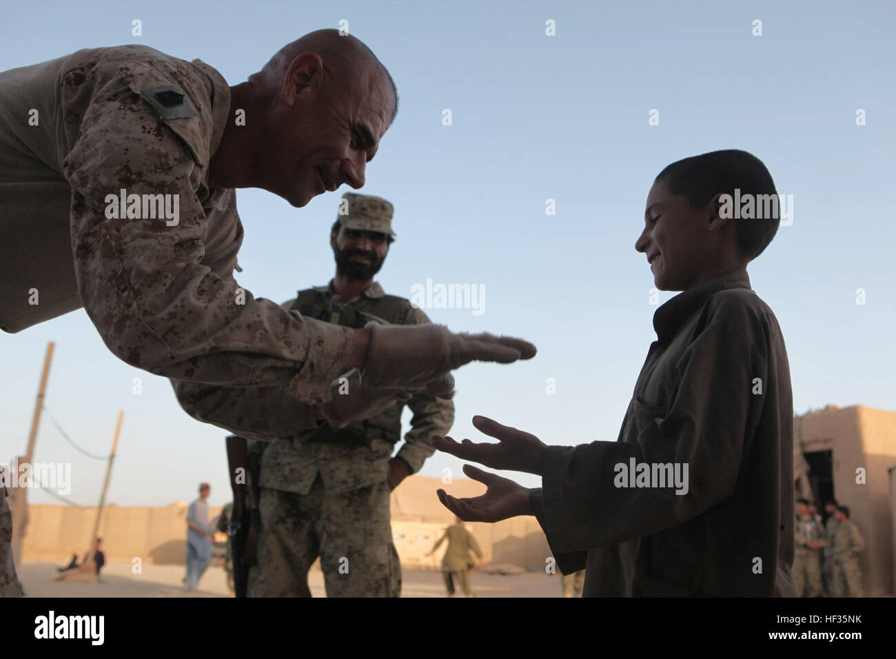 Sgt. Maj. Octaviano Gallegos plays a game with an Afghan child at the ...