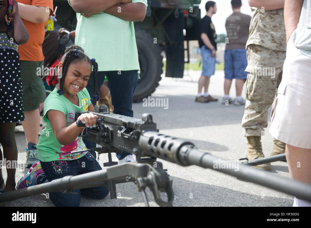 A child attempts to rack the charging handle of a Barrett M2 .50 ...