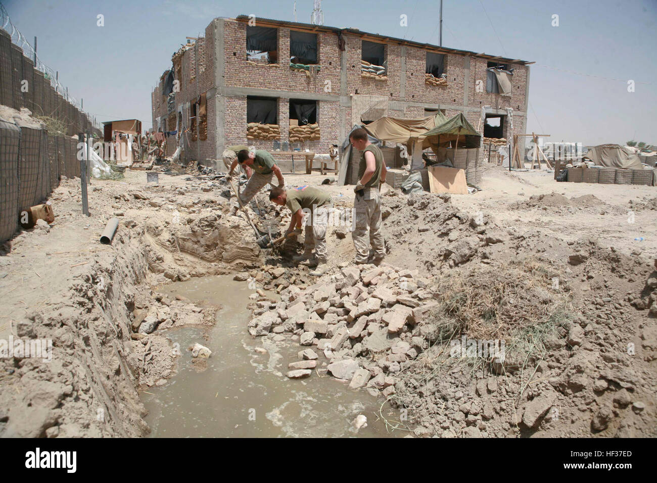 U.S. Marines with 1st Battalion, 5th Marine Regiment dig a drainage ...
