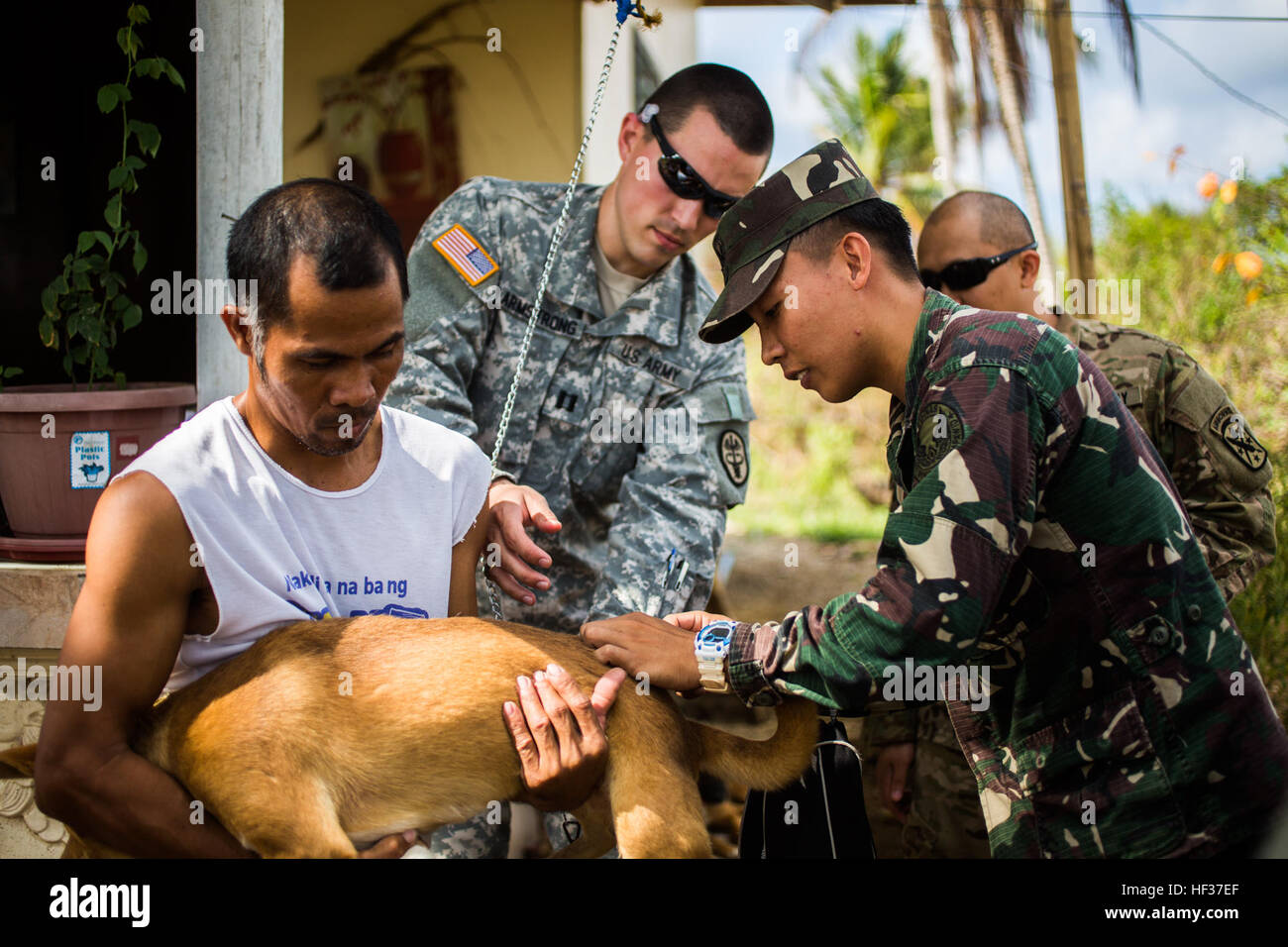 An Airman from the Armed Forces of the Philippines gives a rabies shot ...
